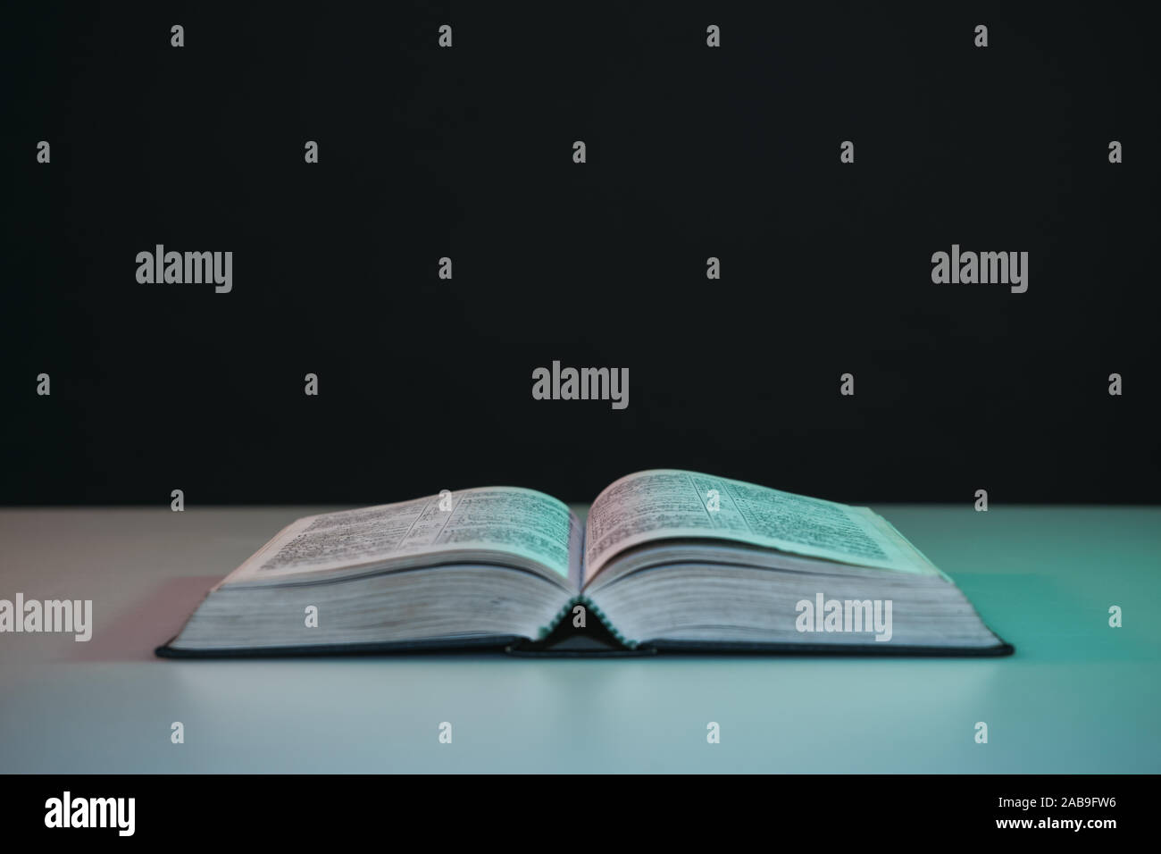 Open bible on a red white table. Beautiful black background Stock Photo ...