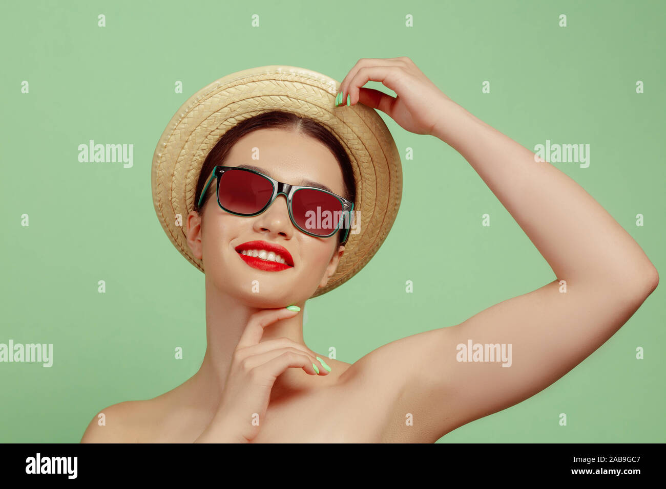 Portrait of beautiful woman with bright make-up, hat and sunglasses on ...