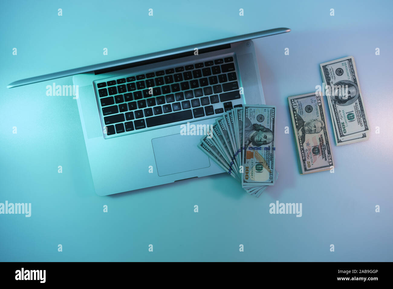 Beautiful silver laptop and cash dollars banknote in the color light on ...