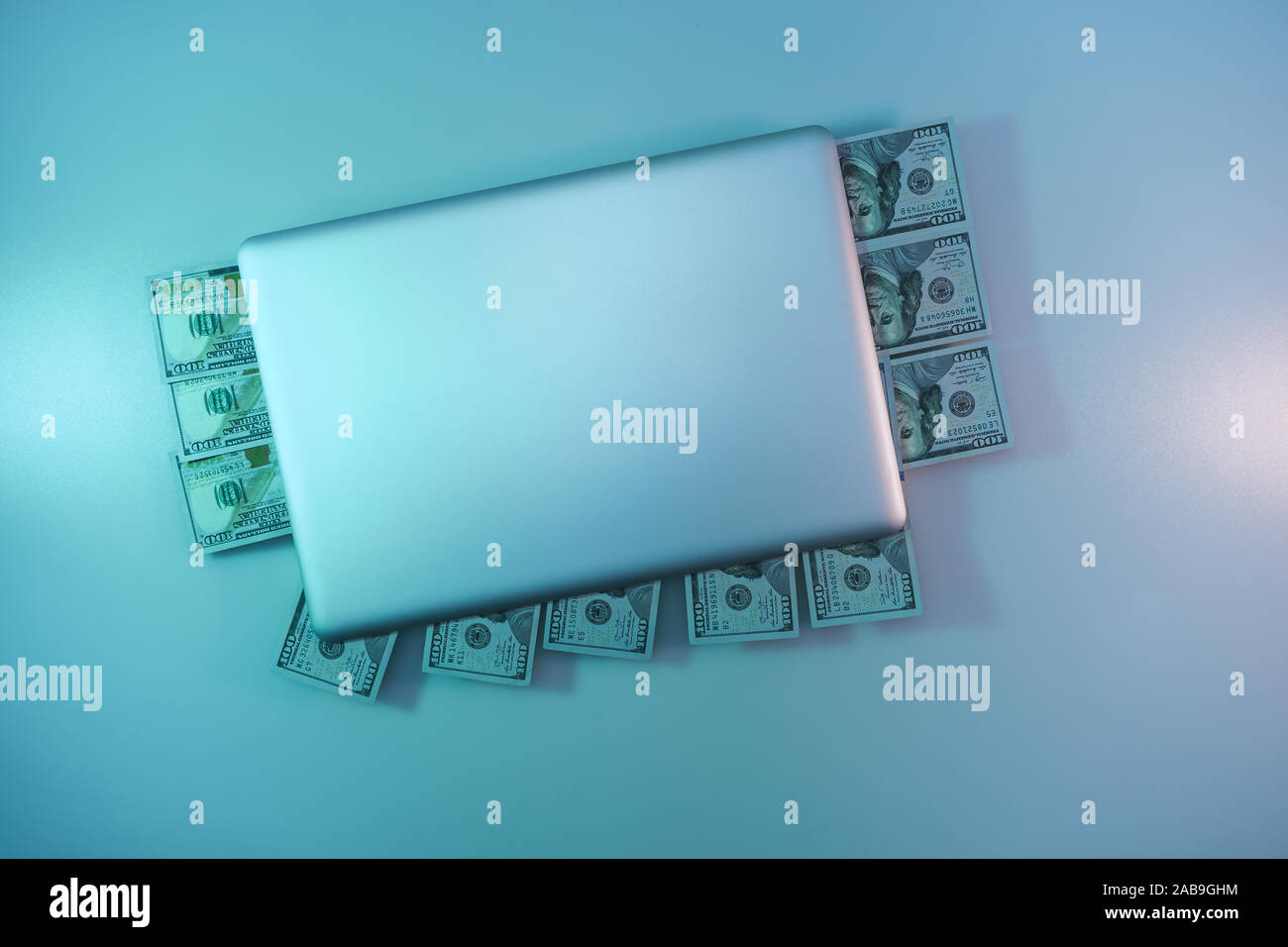 Beautiful silver laptop and cash dollars banknote in the color light on ...