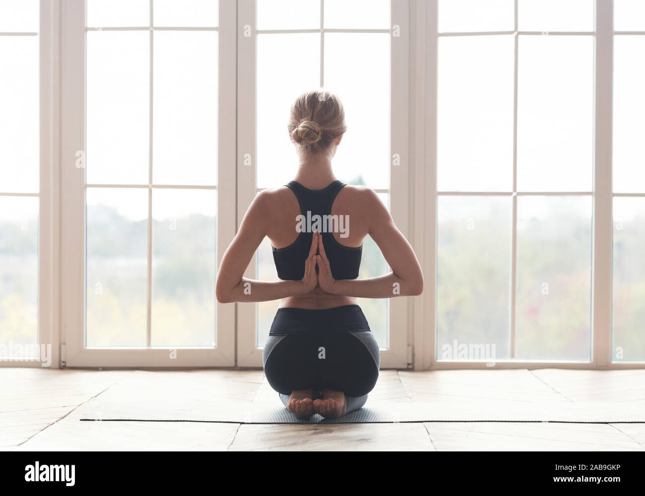 Back view of girl meditating in reverse prayer pose Stock Photo - Alamy