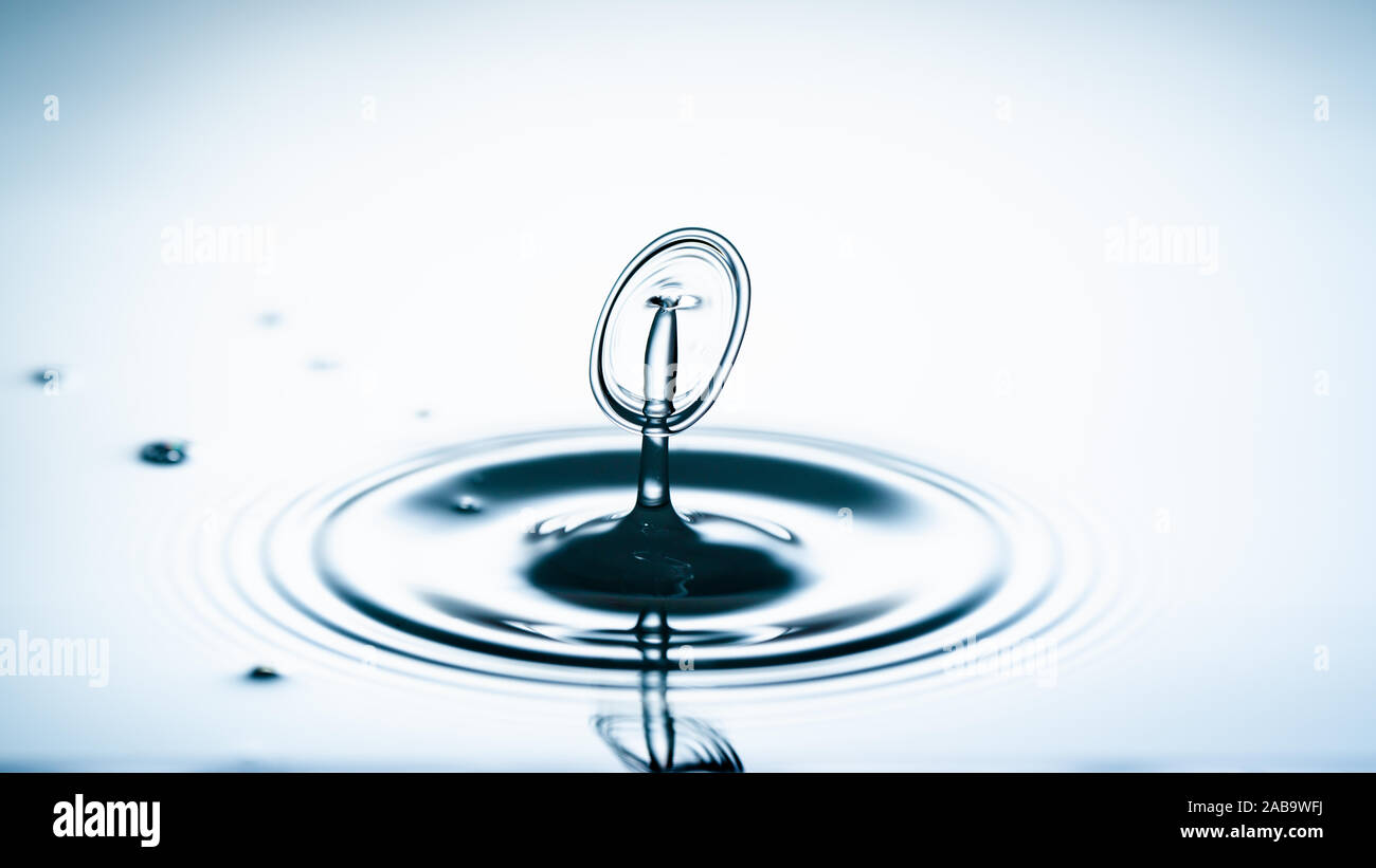Close-up of a water drop falling on water surface Stock Photo - Alamy