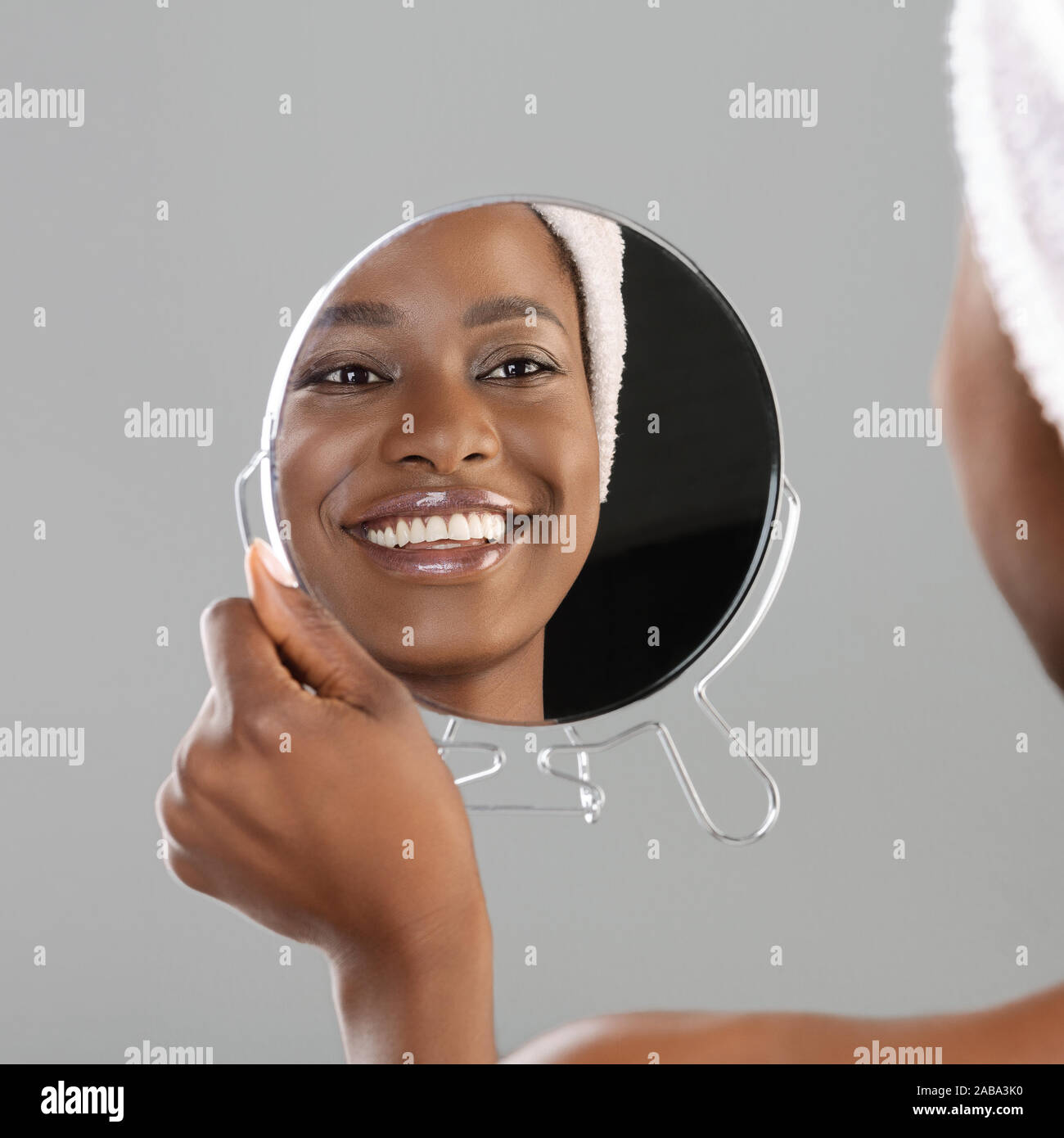 Beautiful black woman reflecting in mirror, admiring her perfect skin ...