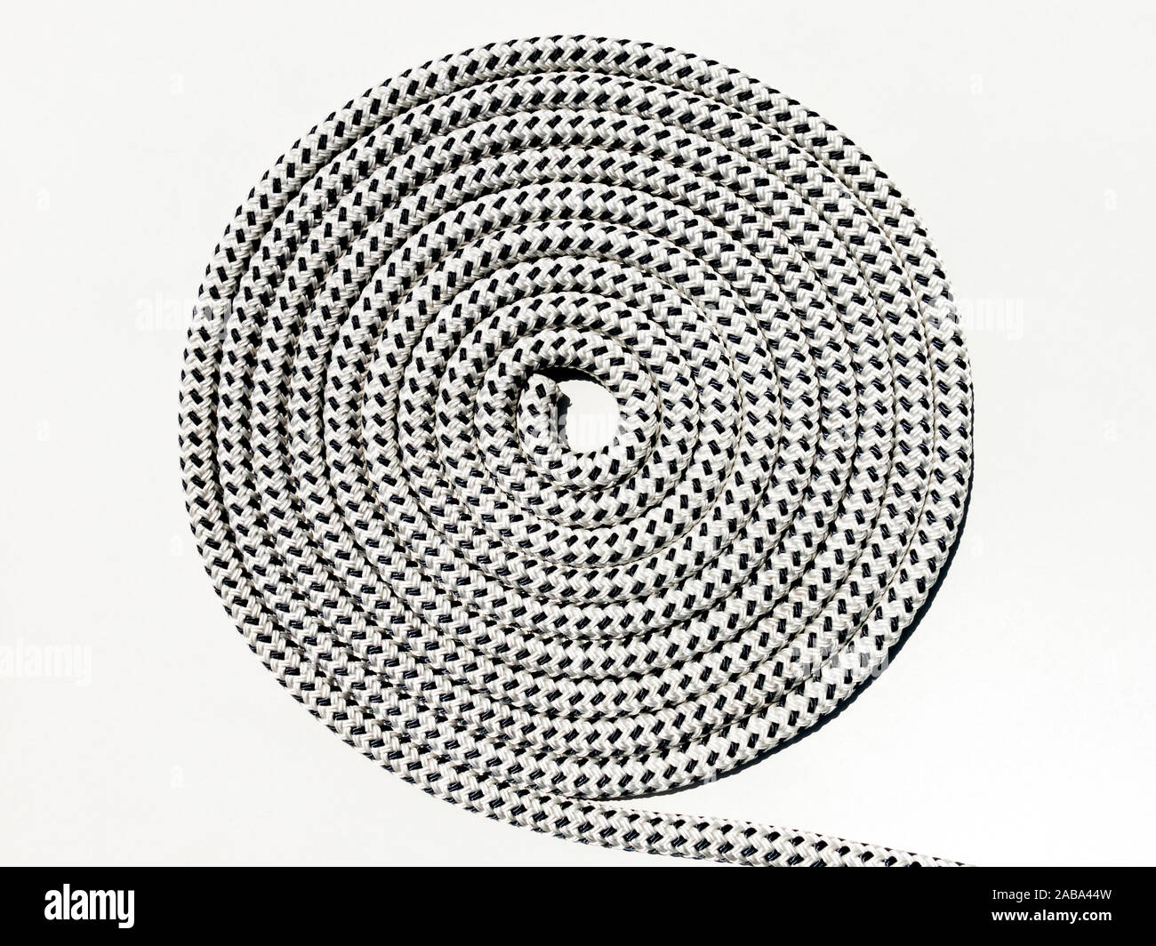 Braided polyester black and white marine rope coiled in a circle on ...