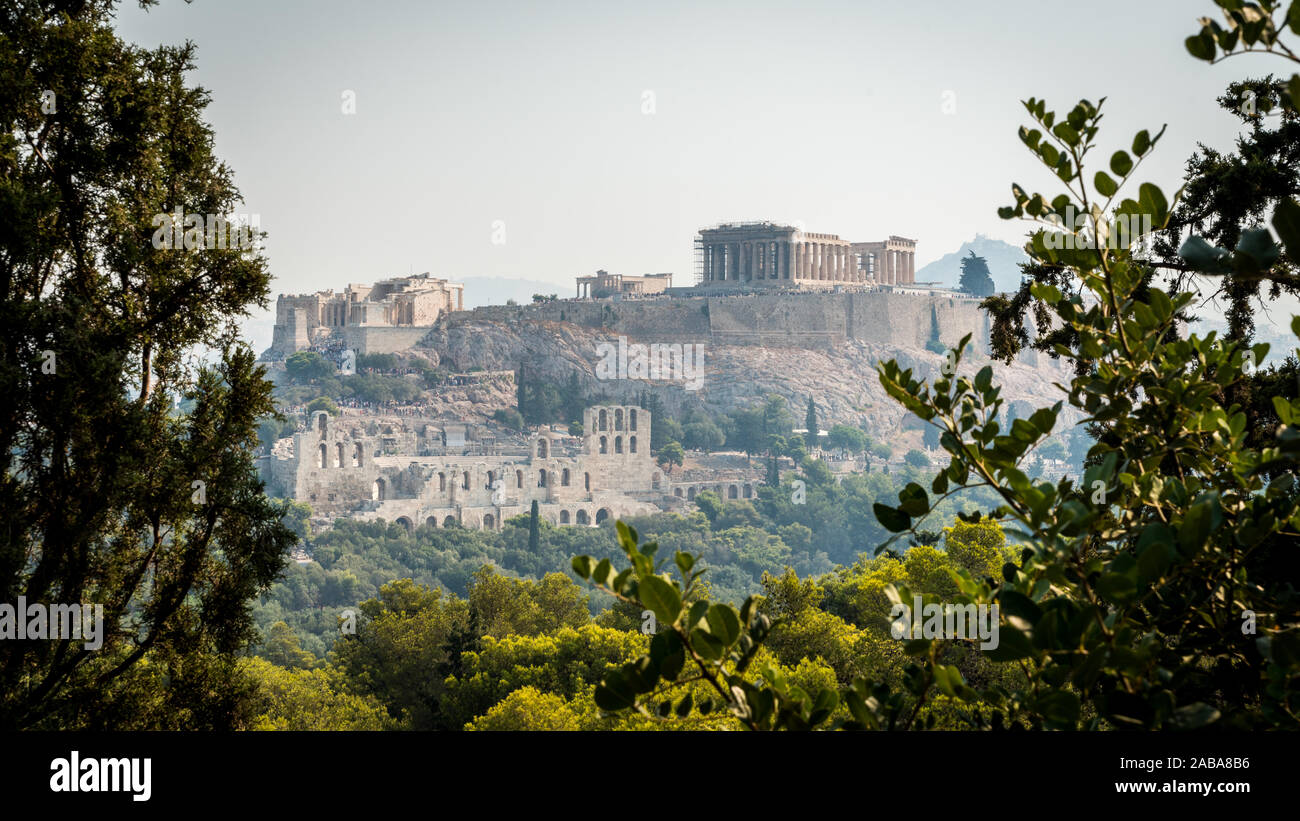 The Acropolis and Parthenon framed by trees and Herodes theater as viewed from Filippapis Hill ...
