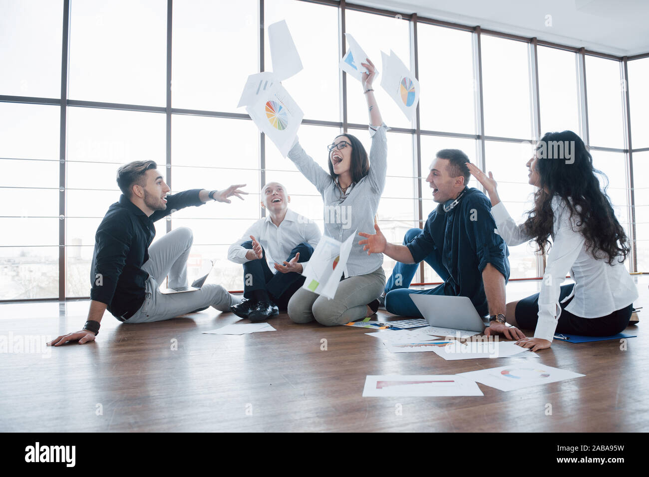 Success strategy together. Cheerful business colleagues tossing papers ...