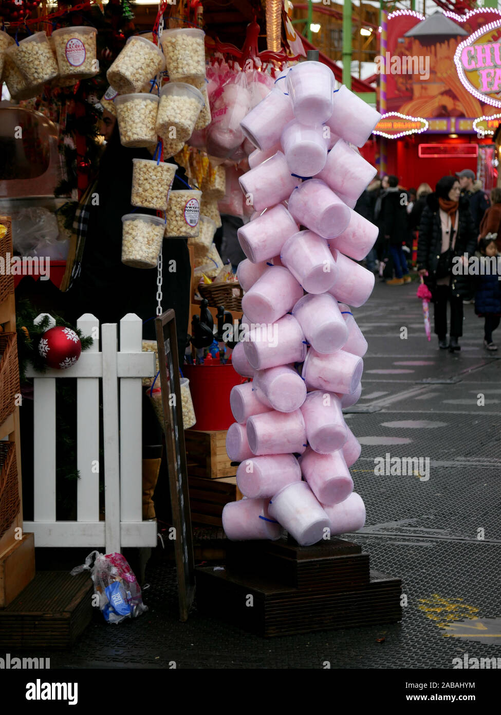 Plastic buckets of candy floss and popcorn for sale on a tall stand ...