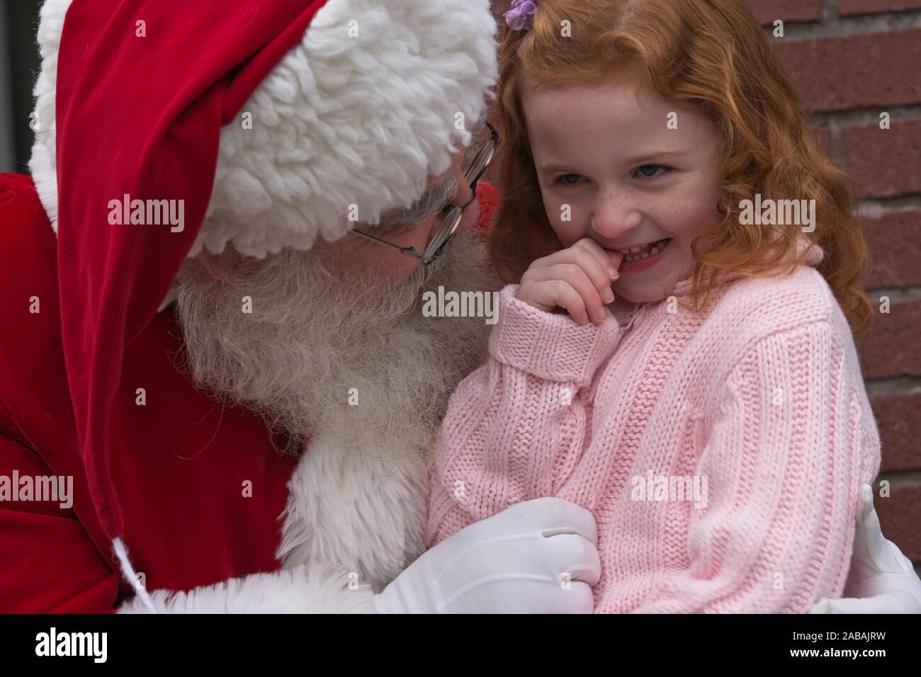 Santa Claus listening to a shy little girl Stock Photo - Alamy