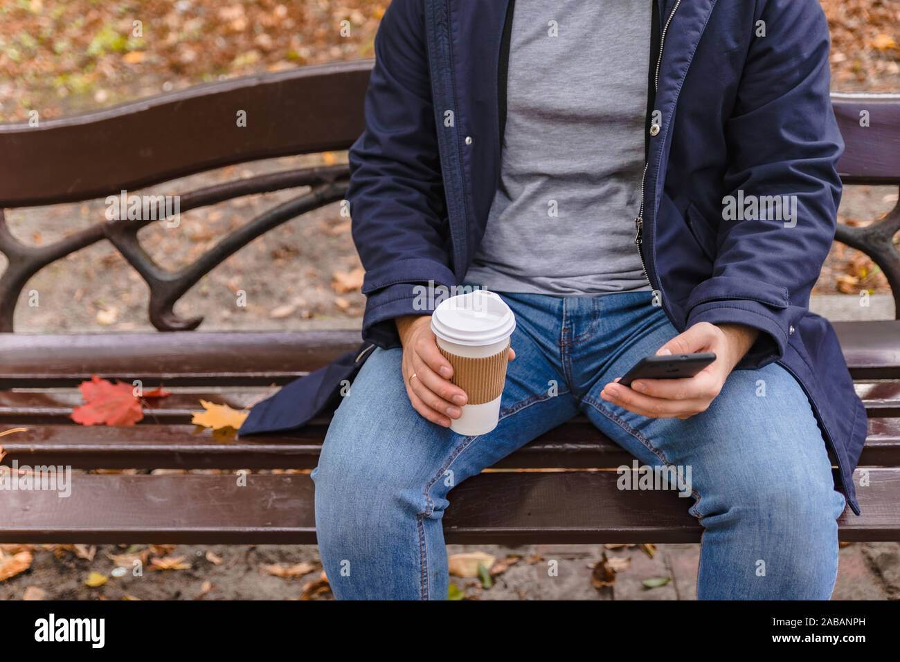 no face man sitting on the bench at city park drinking coffee surfing ...
