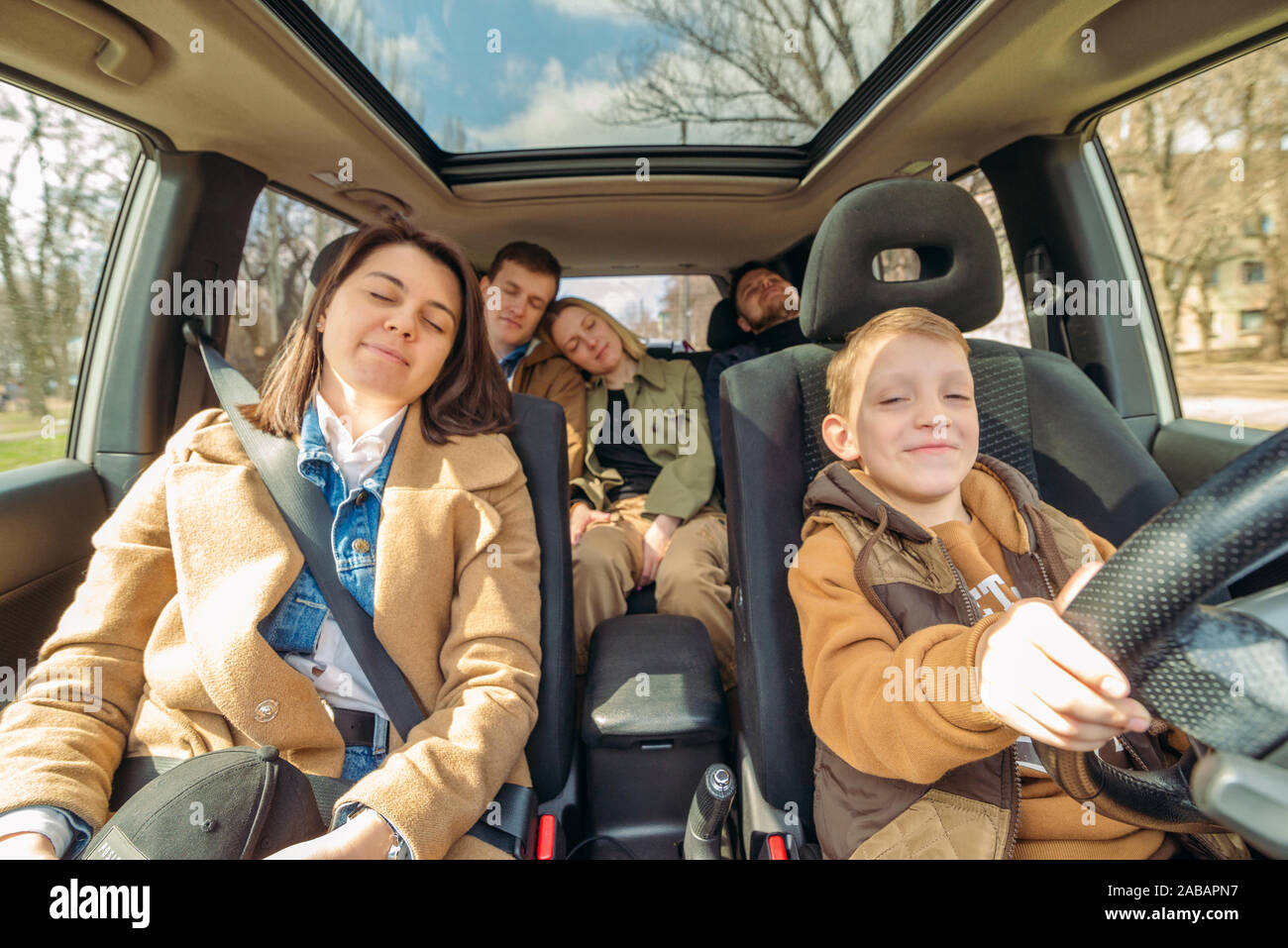 car travel fun concept. little boy driving car with adults people ...