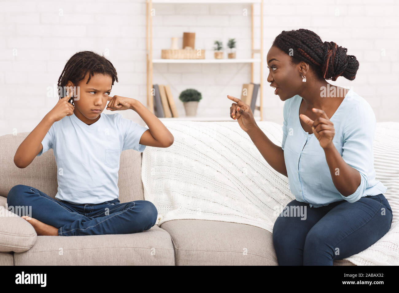 Afro woman lecturing her child who closing ears Stock Photo - Alamy