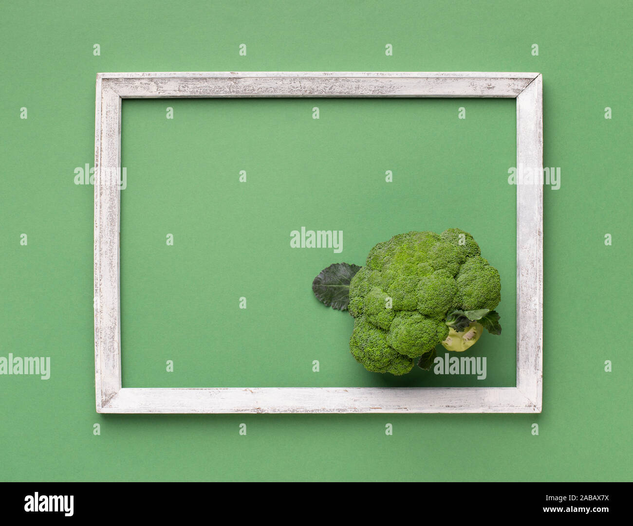 Fresh broccoli inside wooden frame on light green background Stock ...