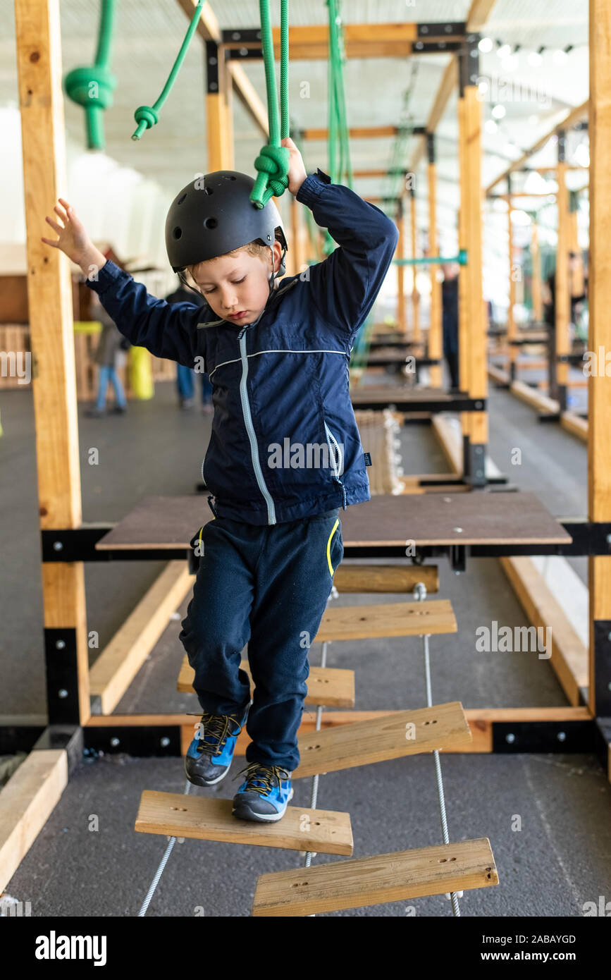 child trying to overcome the obstacles of an adventure park Stock Photo ...