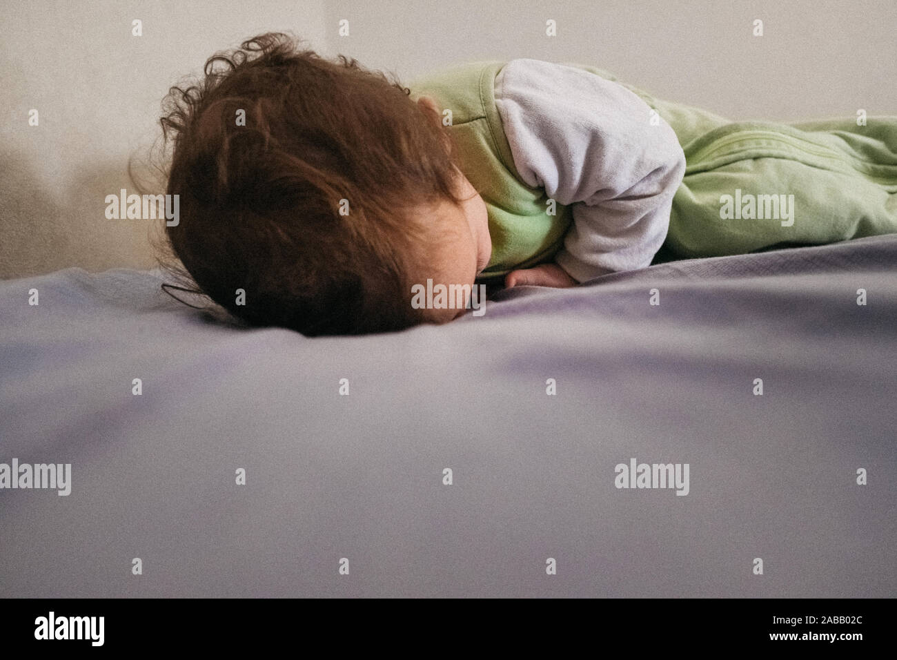 Baby sleeps on a bed in a poor marginal family Stock Photo - Alamy
