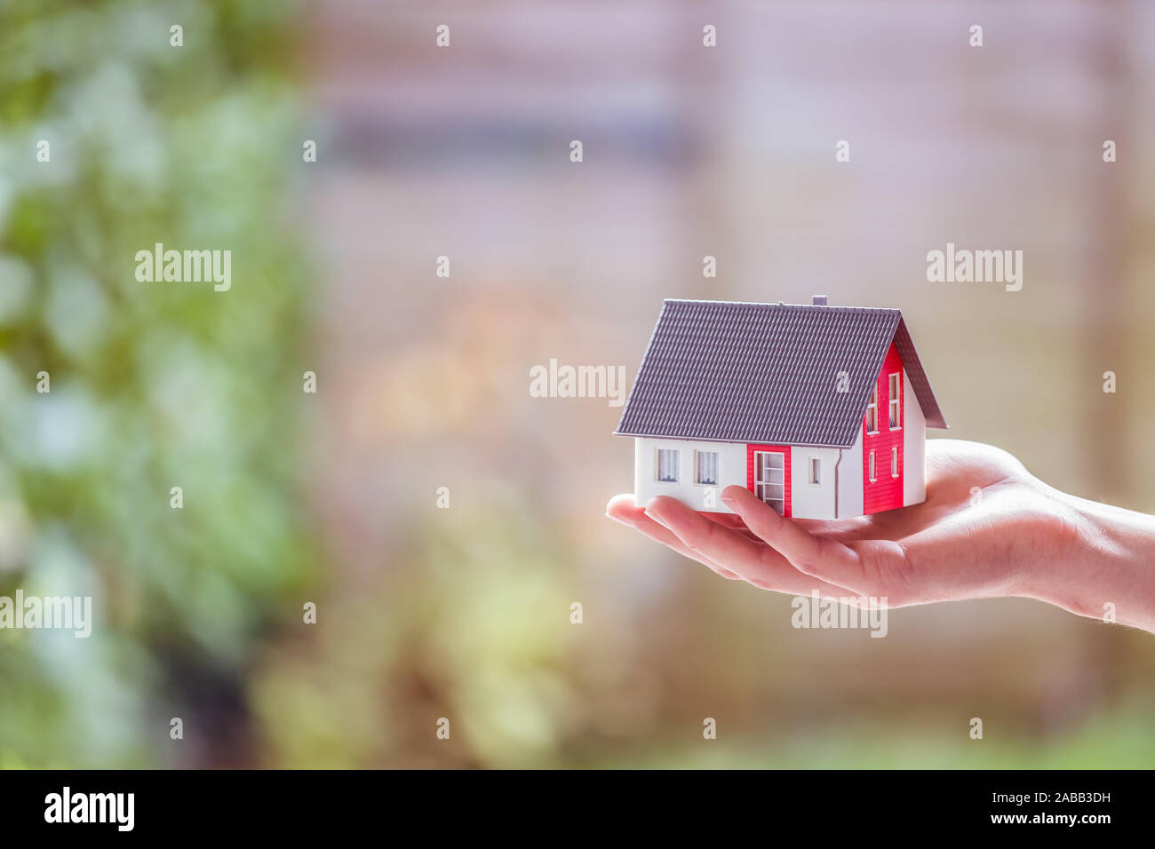 New home and house concept: Red house model outdoors in male hand Stock ...