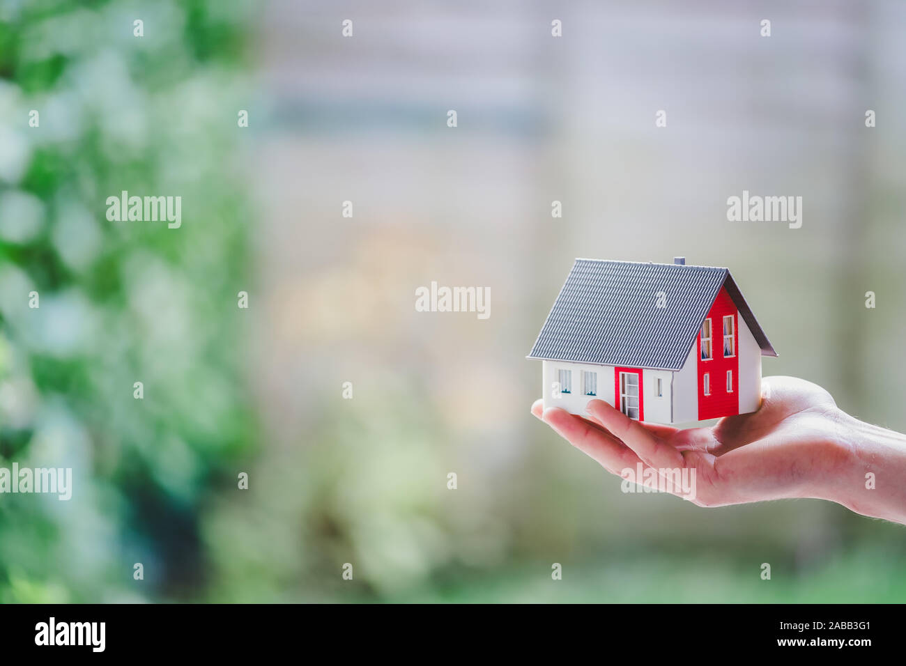 New home and house concept: Red house model outdoors in male hand Stock ...