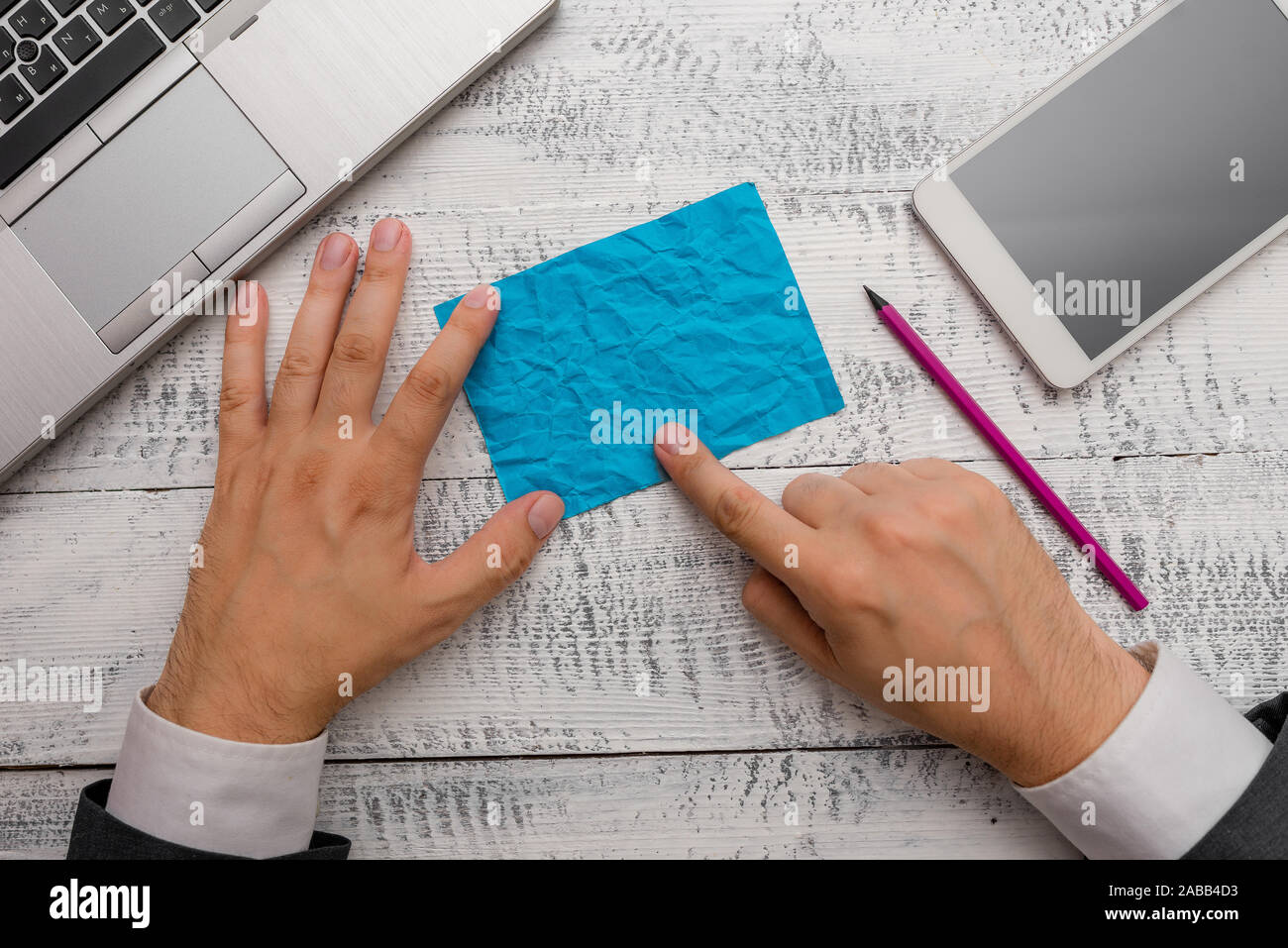 Hand hold note paper near writing equipment and modern smartphone ...