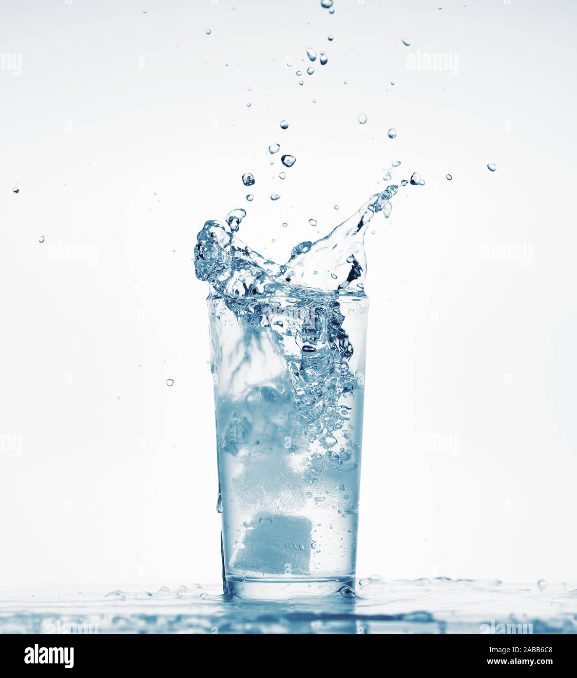 one glass of water with splash from falling ice cube, white background, isolated object Stock ...