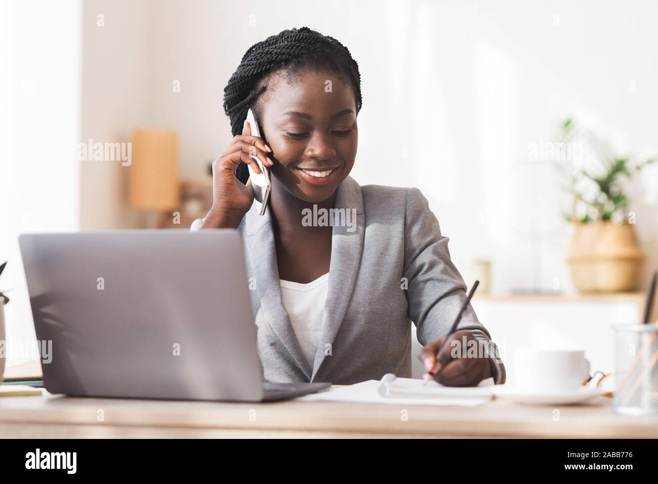 Afro Secretary Taking Notes And Talking On Cellphone In Office Stock ...