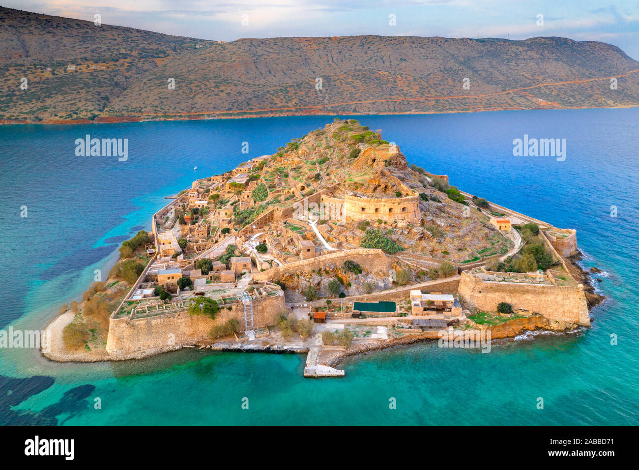 Aerial view of the island of Spinalonga with calm sea. Here were ...