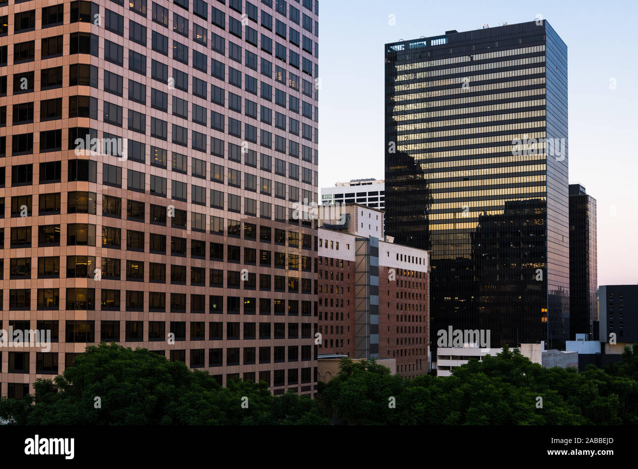 Row of modern office buildings reflecting the light of sunset above ...