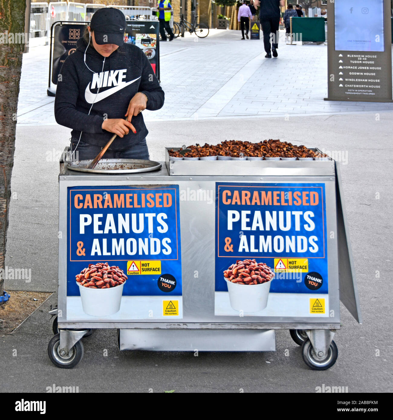 Street food vendor with heated trolley selling cups of Caramelised ...
