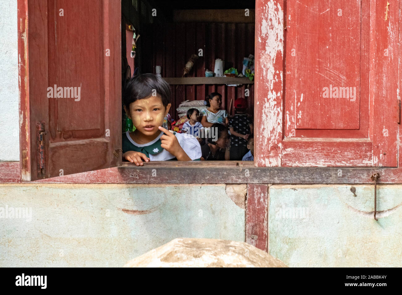 A Young Girl Leans Out Of Her Elementary School Kindergarten Classroom
