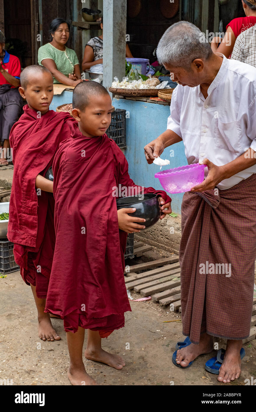 Two young Buddhist monks dressed in scarlet robes enter the market of ...