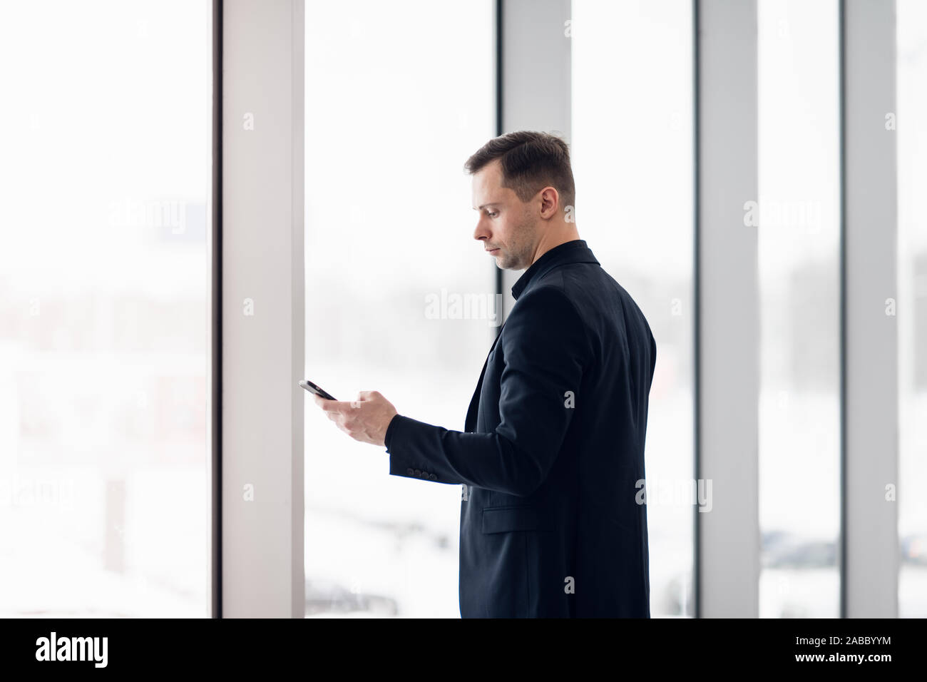 Business man using mobile phone app in airport. Young business ...