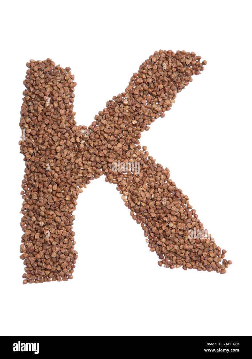 Letter K of the English alphabet from brown dry buckwheat on a white ...