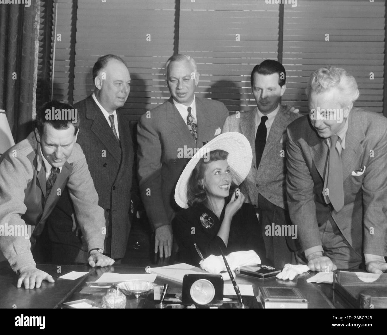 THE DIARY OF A CHAMBERMAID, Paulette Goddard (seated) signs her ...