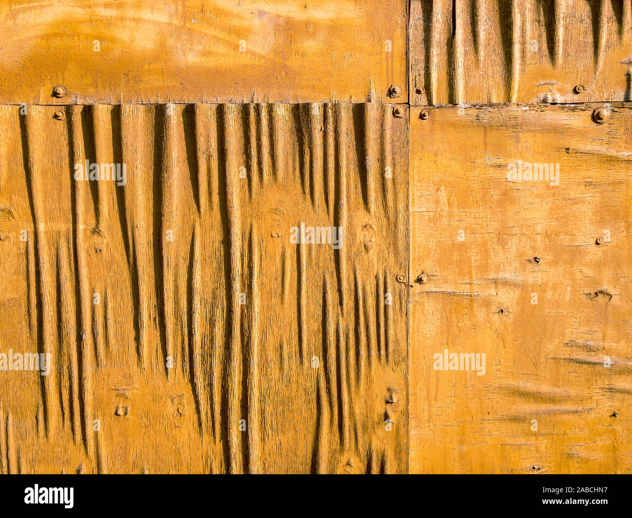 old weathered plywood wall background texture with orange flaked paint ...