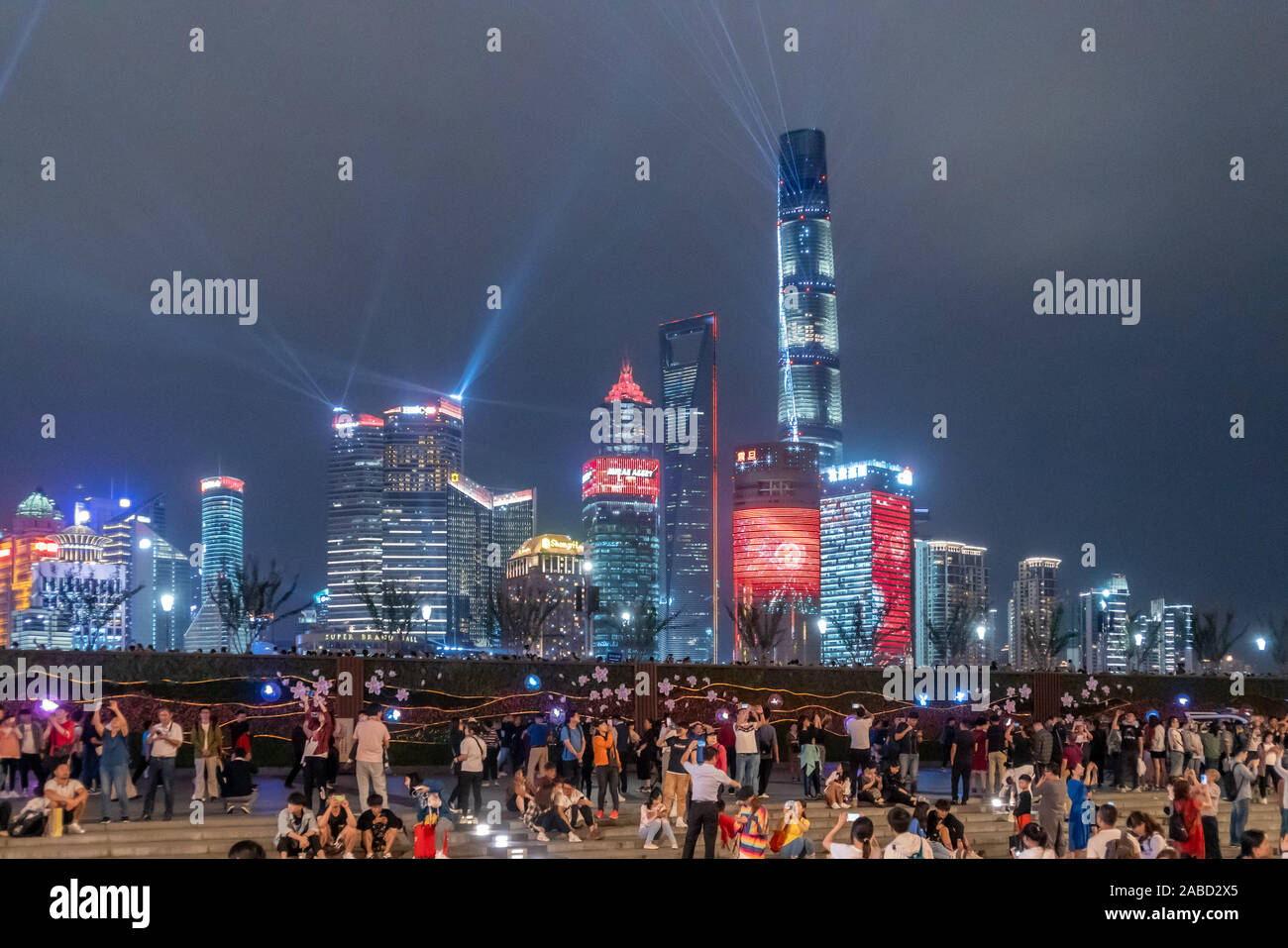 Tourists gather at the Bund to enjoy the light show performed with ...