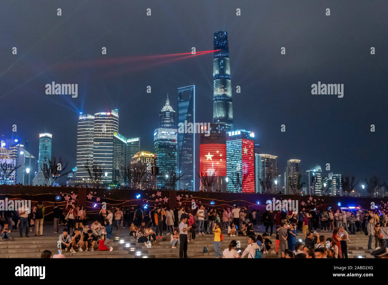 Tourists gather at the Bund to enjoy the light show performed with ...