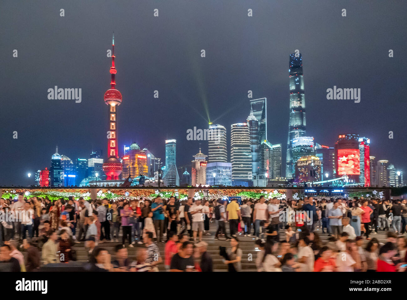 Tourists gather at the Bund to enjoy the light show performed with ...