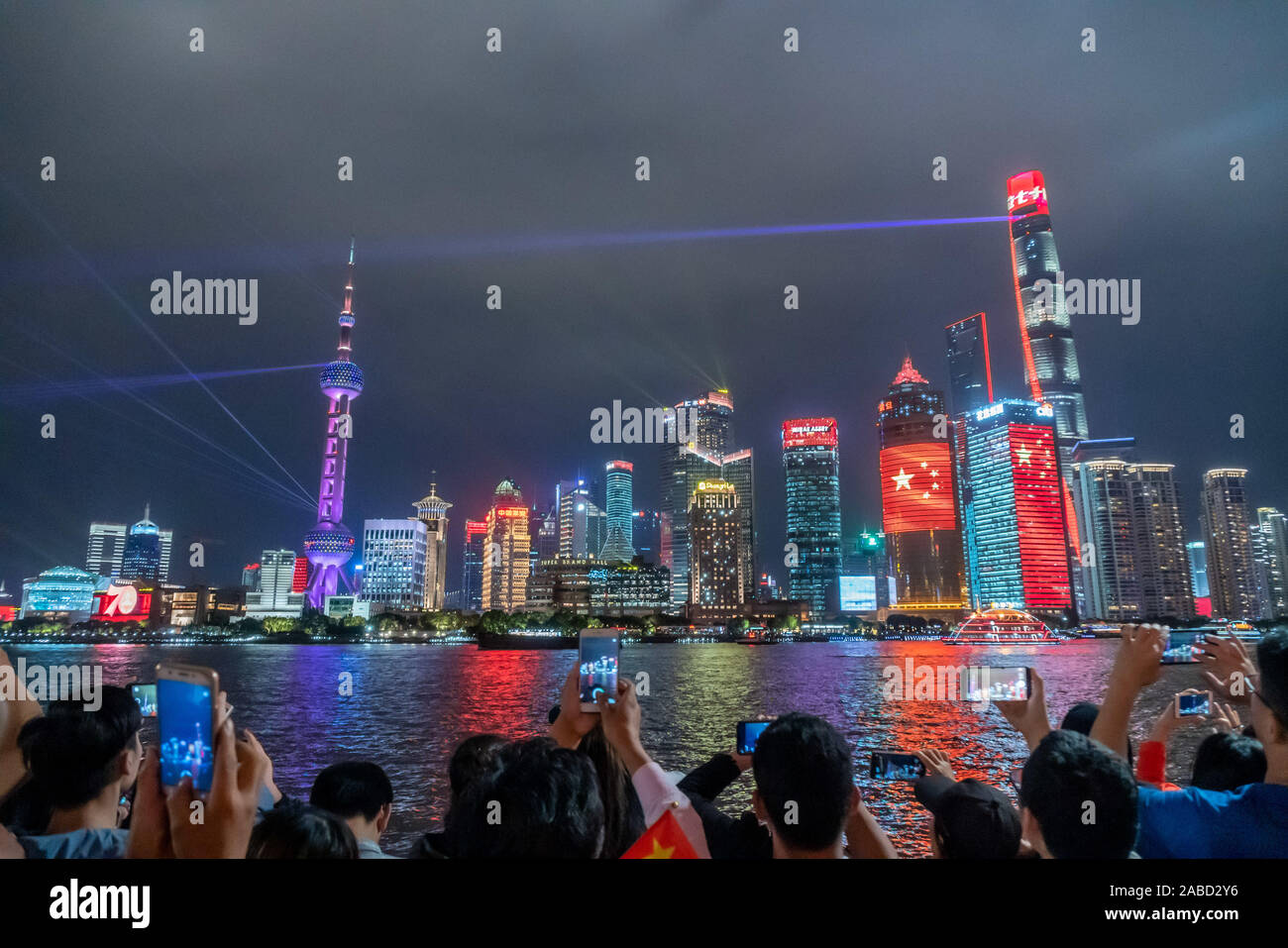 Tourists gather at the Bund to enjoy the light show performed with ...