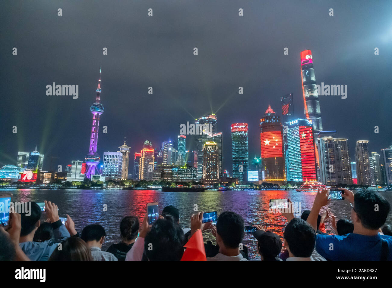 Tourists gather at the Bund to enjoy the light show performed with ...