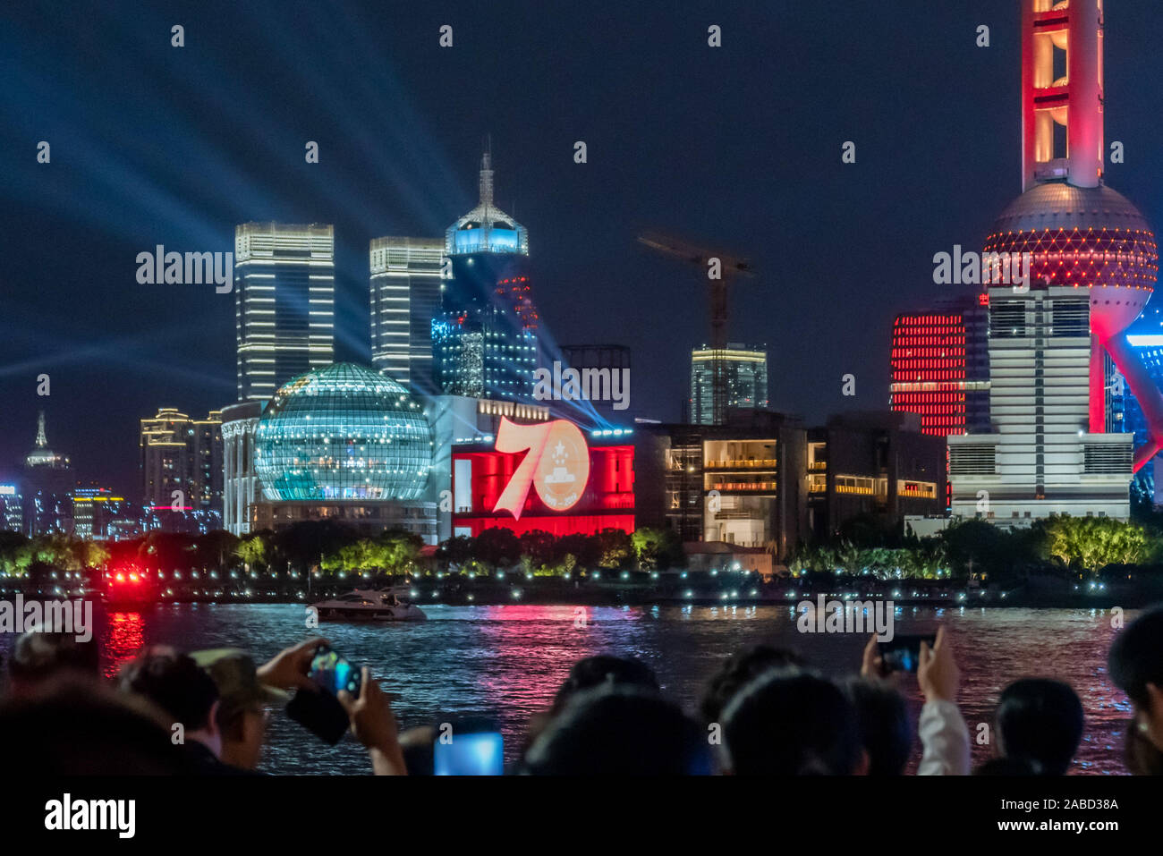 Tourists gather at the Bund to enjoy the light show performed with ...