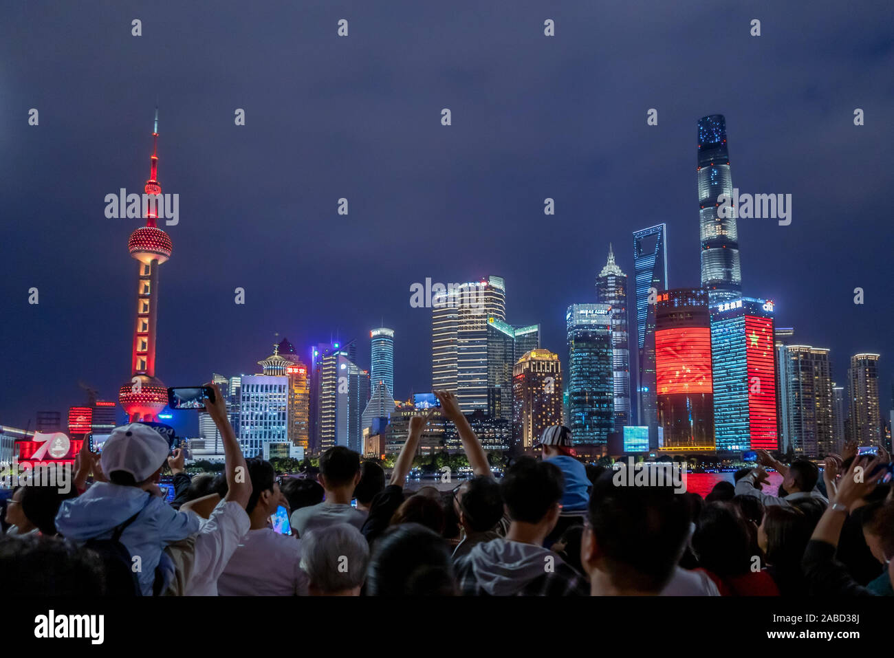 Tourists gather at the Bund to enjoy the light show performed with ...