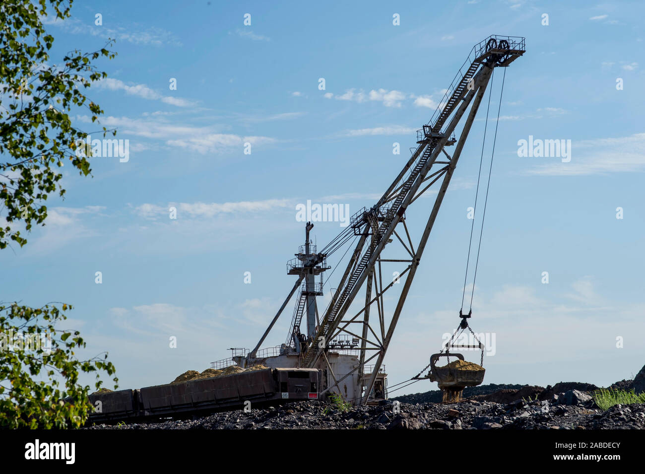 The huge excavator stacks in dumps rock brought from the mine and ...