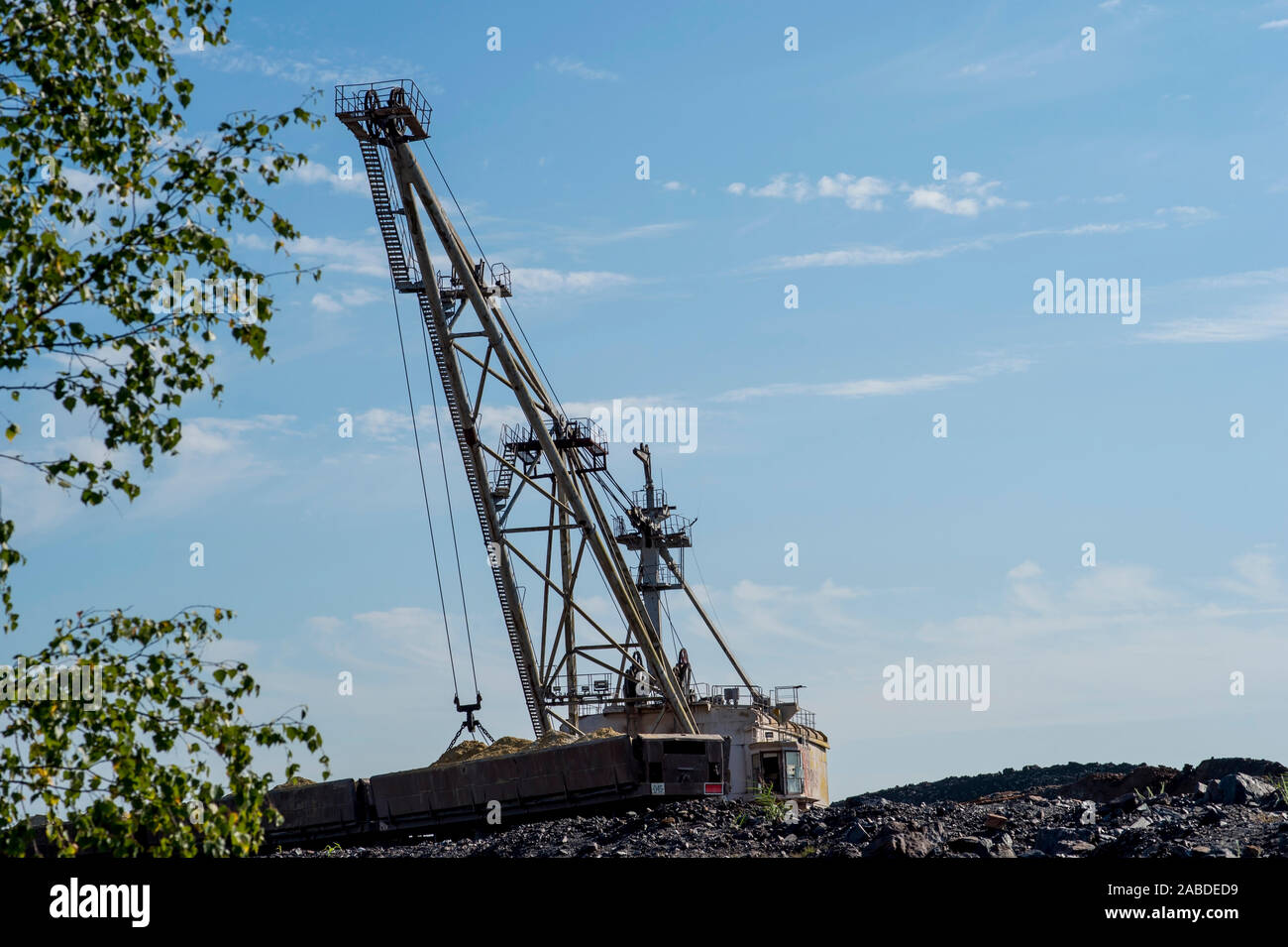 The huge excavator stacks in dumps rock brought from the mine and ...