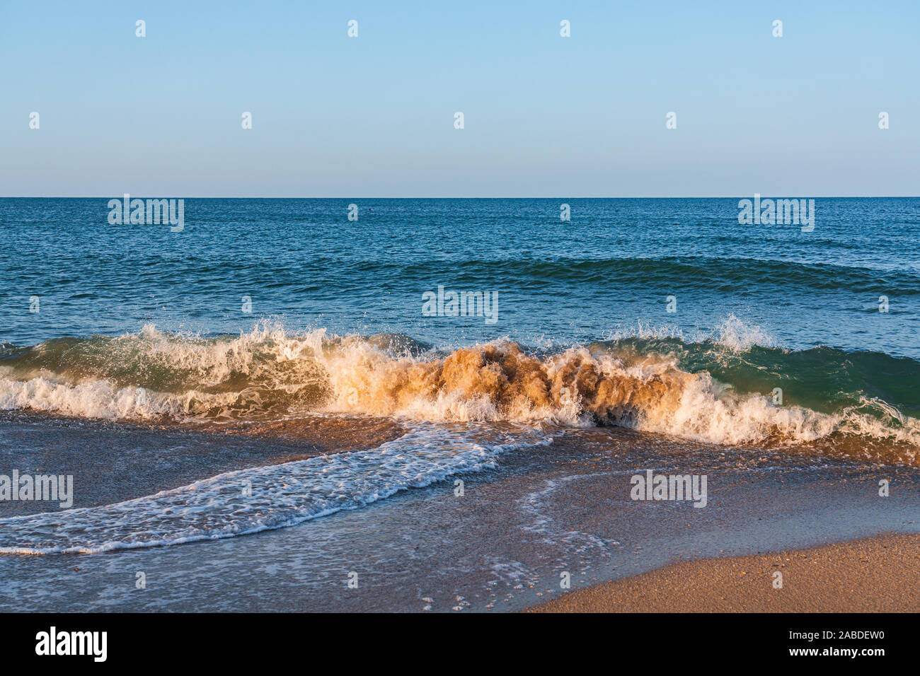 Sea surf on the yellow sand beach Stock Photo - Alamy