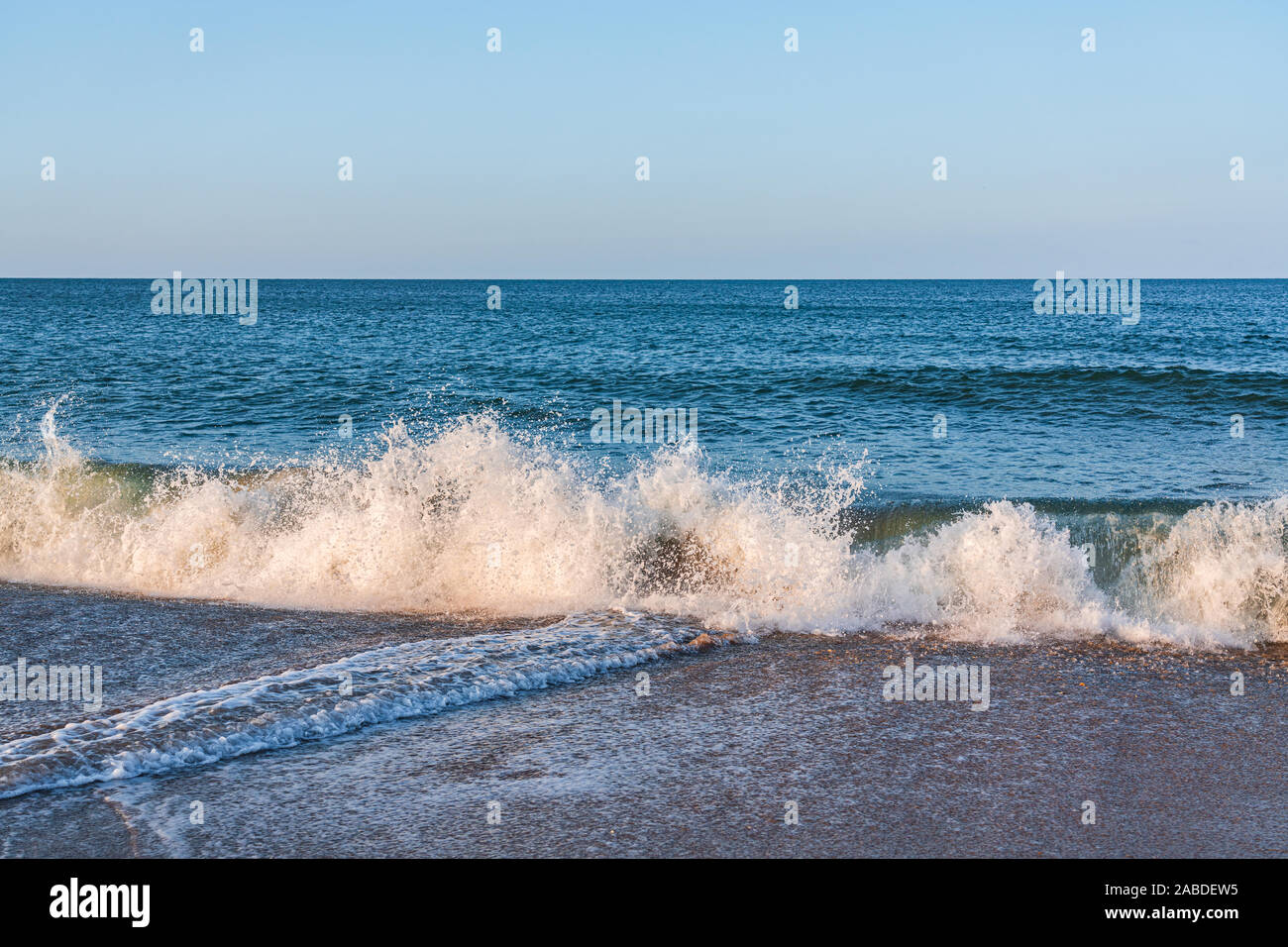 Sea surf on the yellow sand beach Stock Photo - Alamy