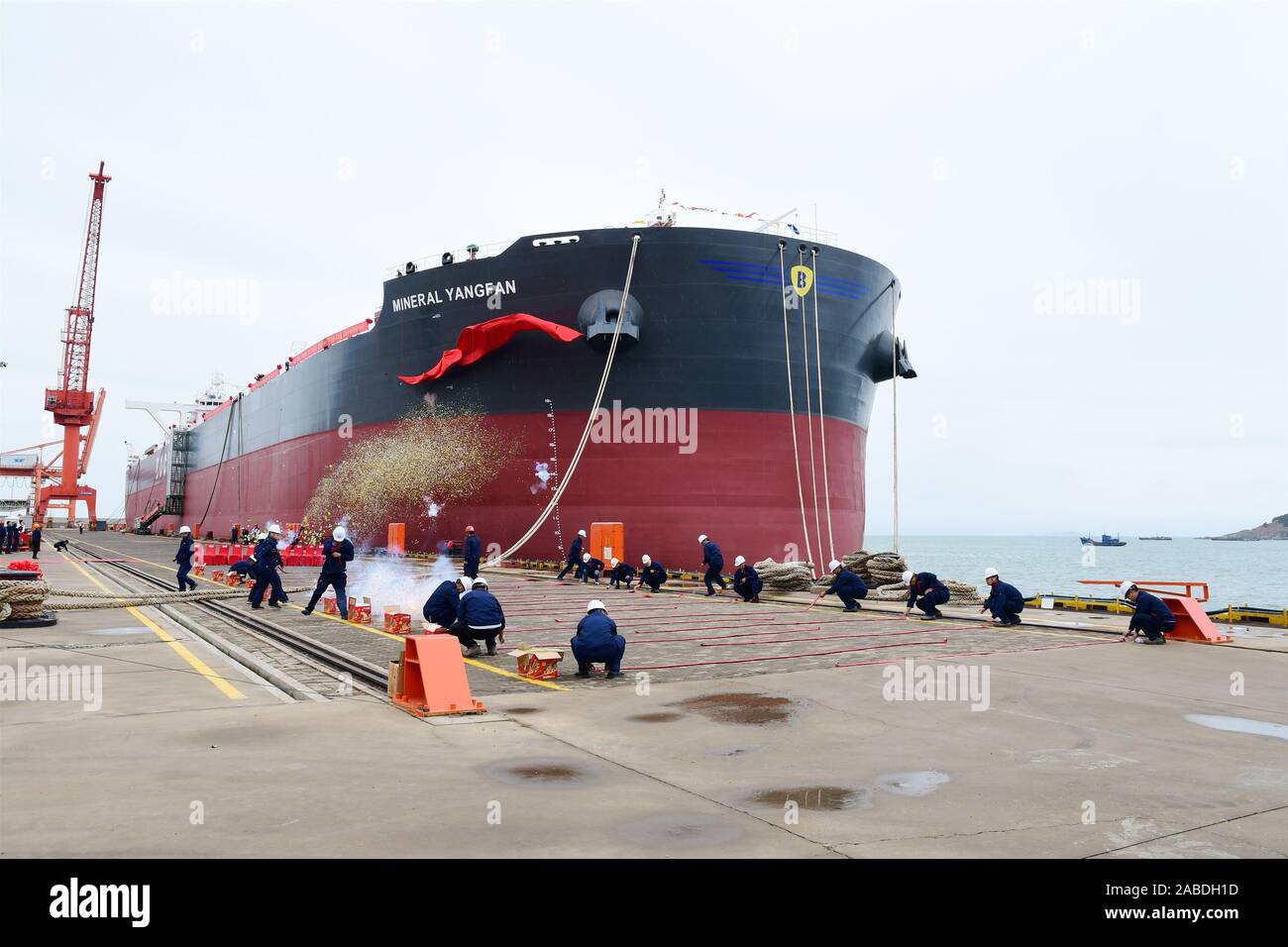 Workers set fireworks to celebrate the completion of the bulk cargo ...