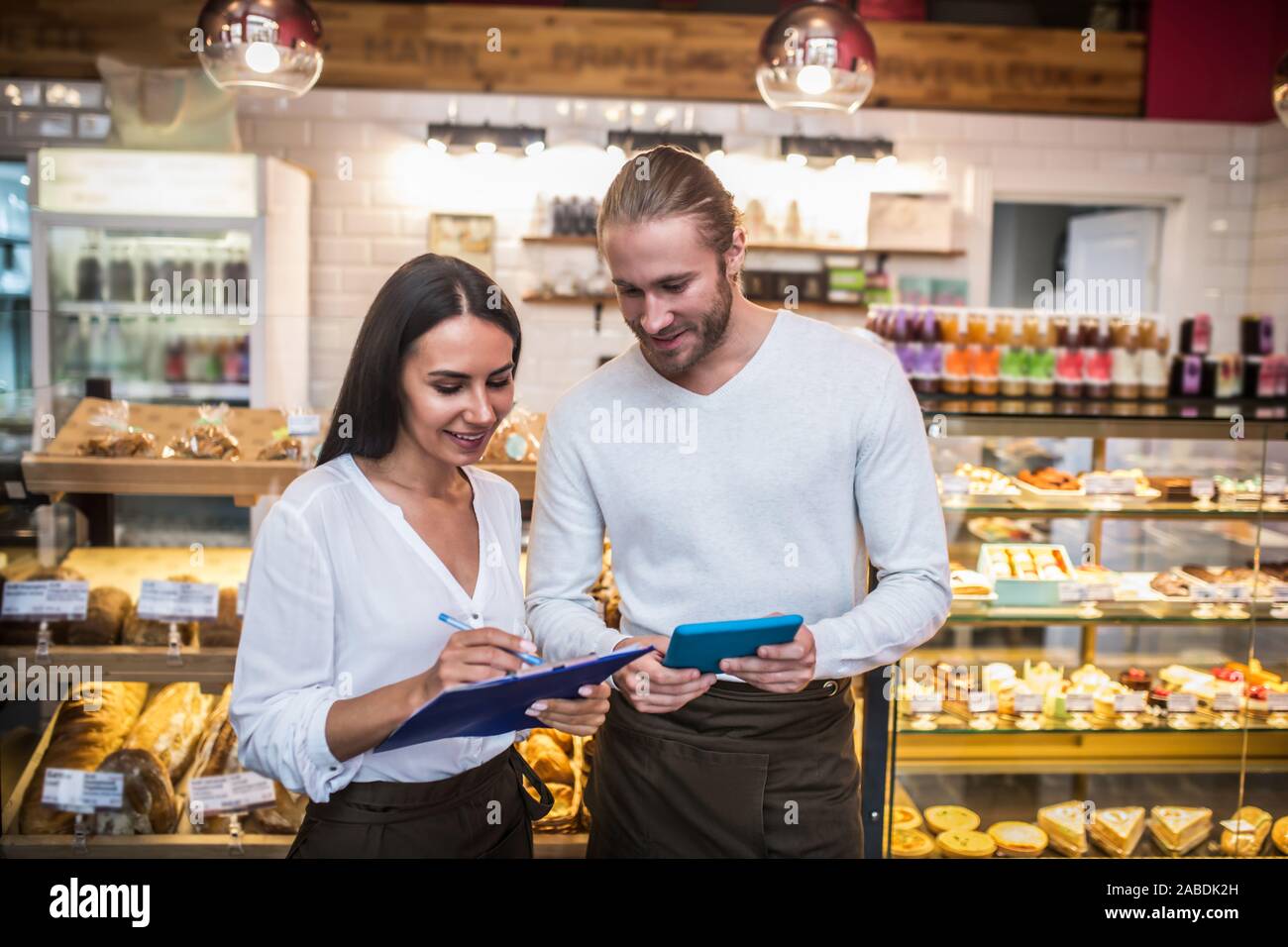 Husband and wife making notes calculating profits at the end of the ...