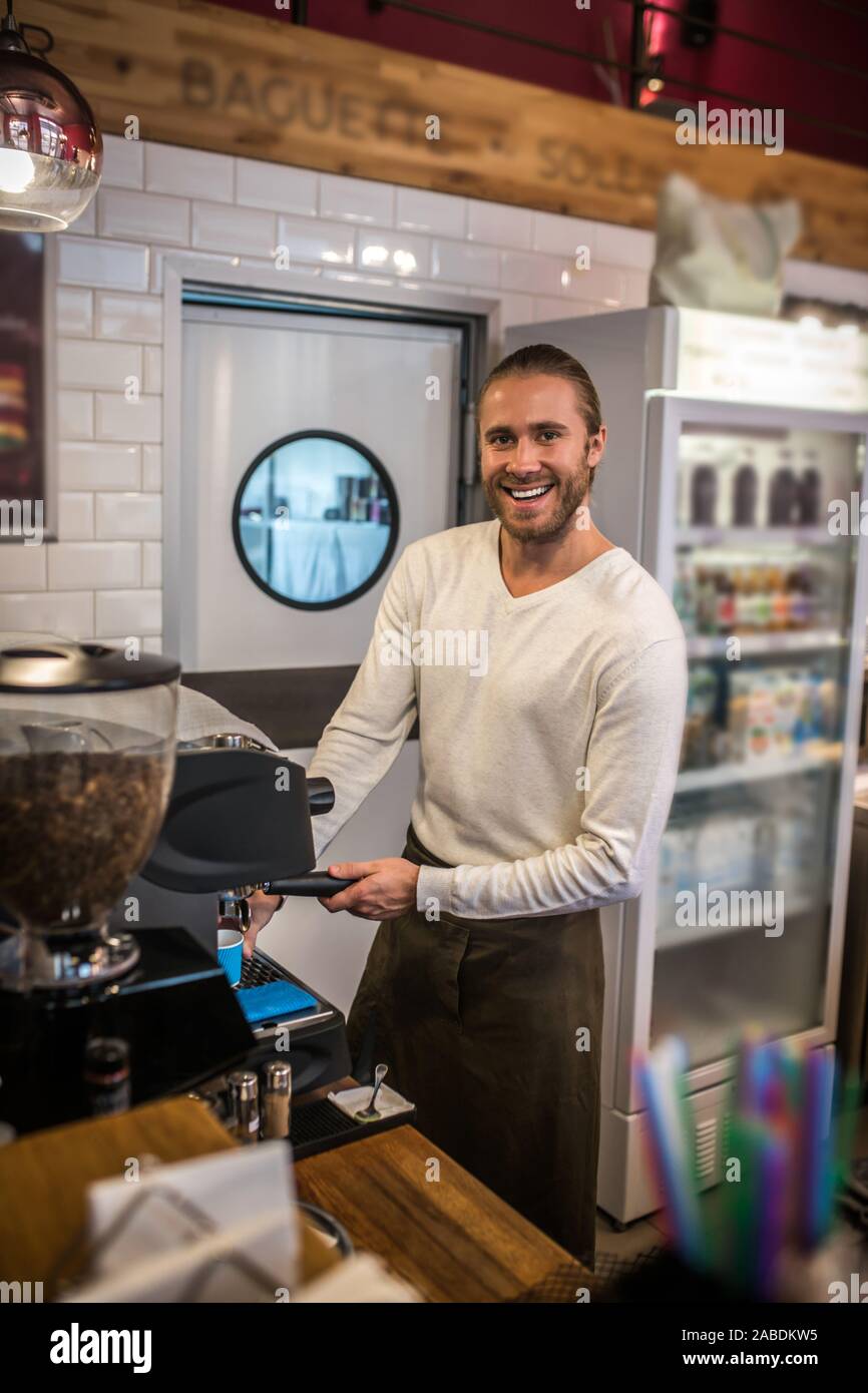 Cheerful barista feeling excited while working and making coffee Stock ...