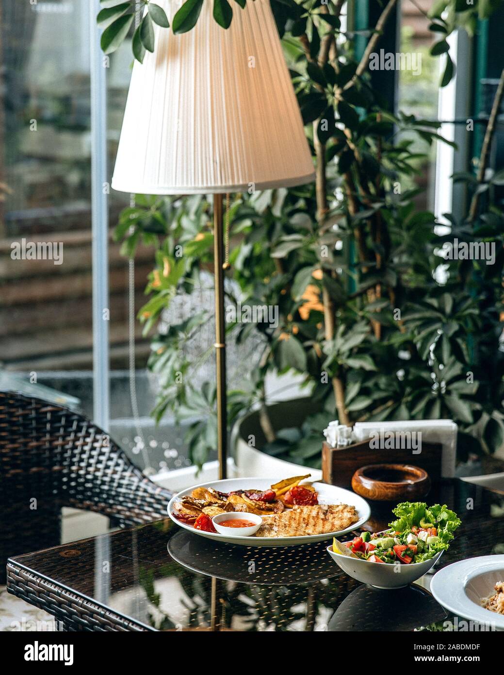 lunch setup at the restaurant near the window and floor stand lamp ...
