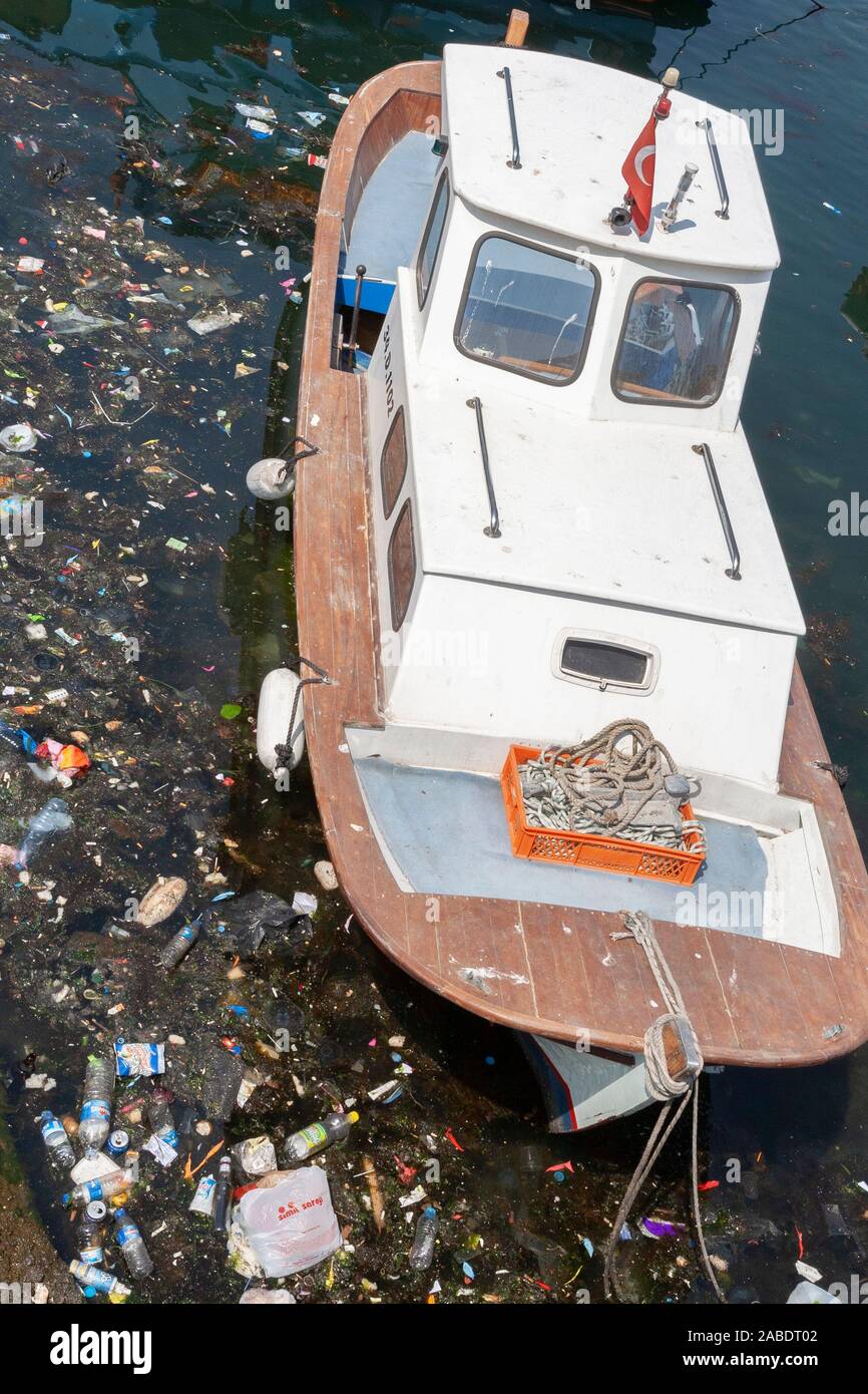 boat in sea next to plastic pollution Stock Photo - Alamy
