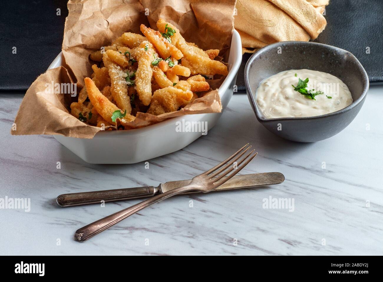 New England fried clam strips served with a bowl of tartar dipping ...