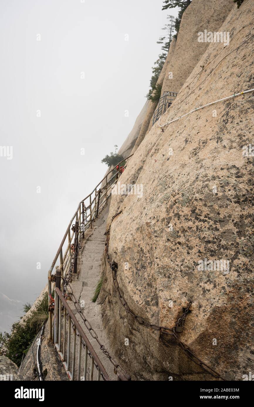 Stone steps cut on a side of a mountain rock leading to the dangerous ...